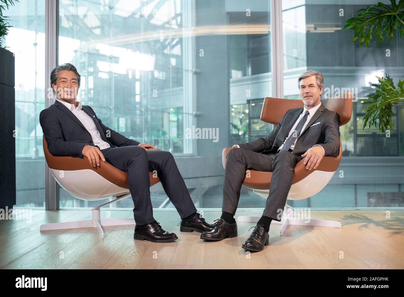 Two businessmen talking in office Stock Photo - Alamy