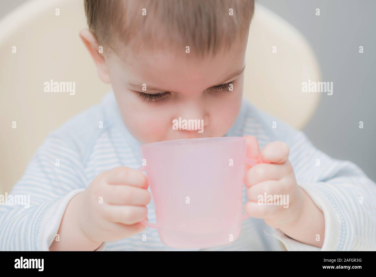 the child in the kitchen drinks water Stock Photo - Alamy