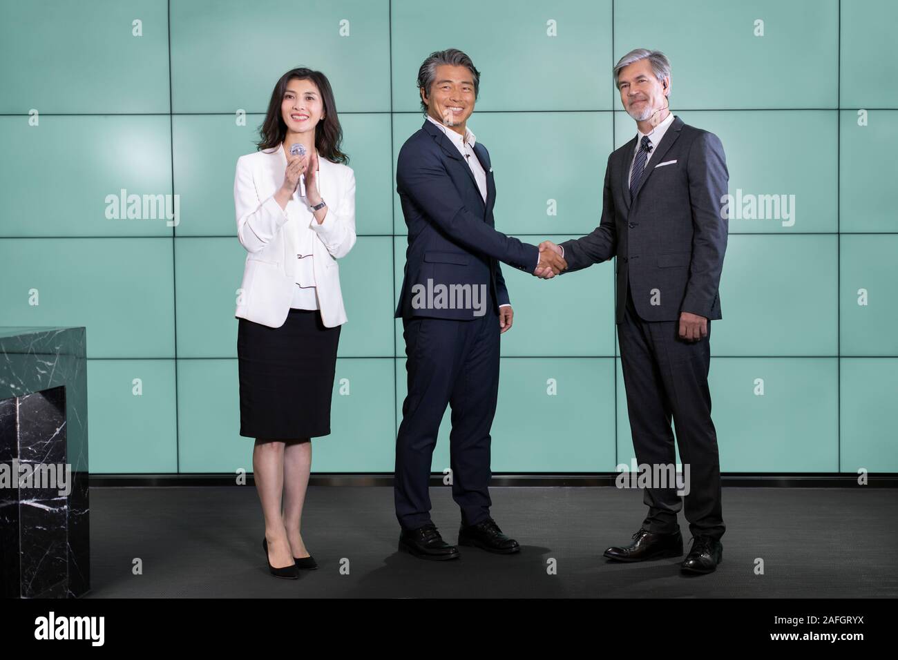 Businessmen shaking hands on stage Stock Photo - Alamy