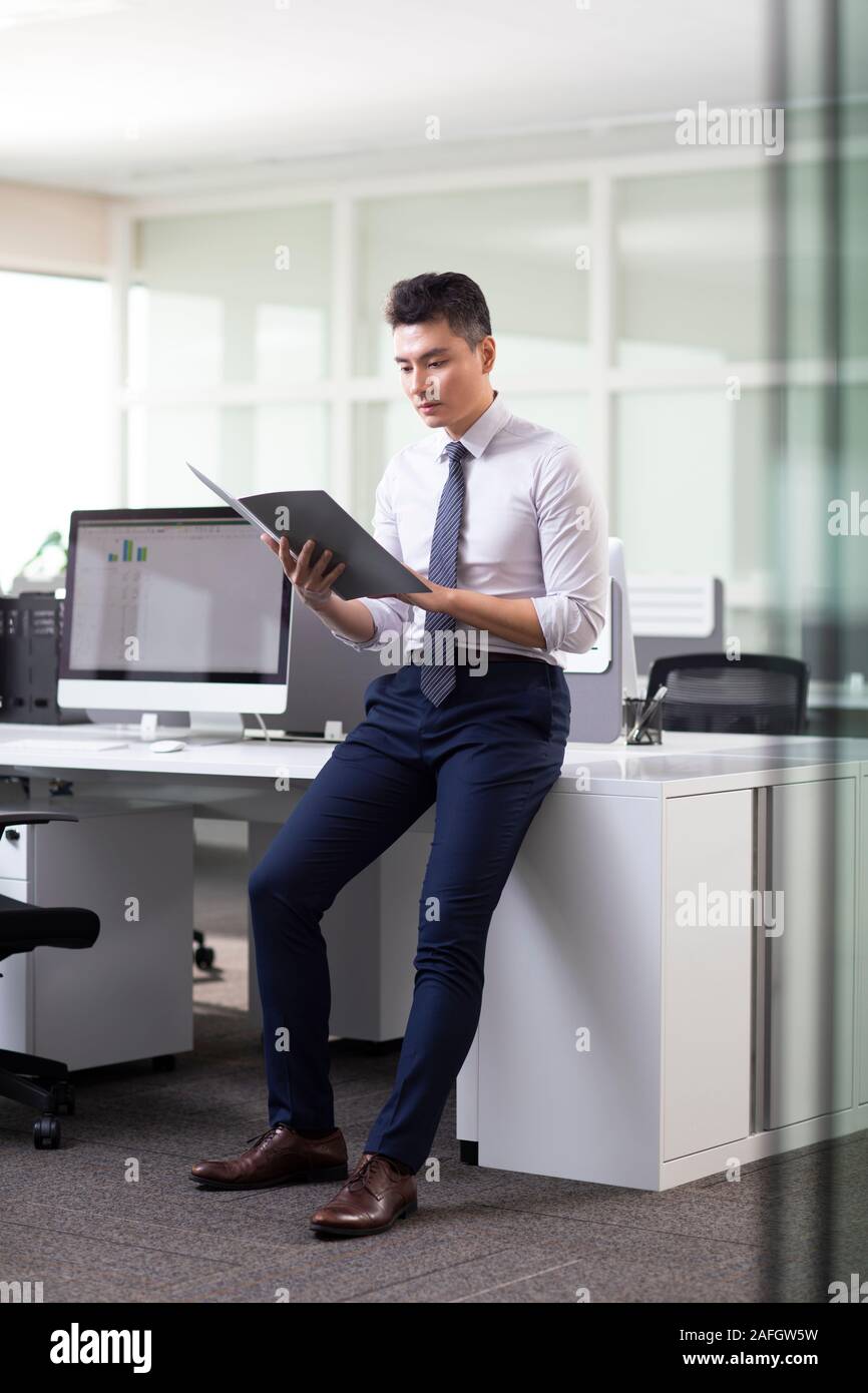 Successful businessman reading file in office Stock Photo - Alamy