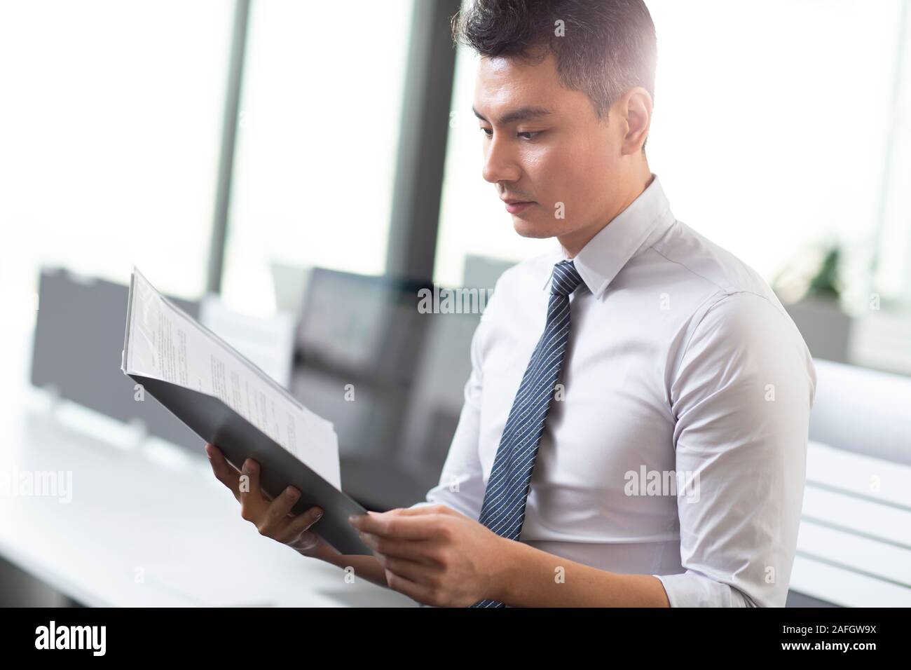 Successful businessman reading file in office Stock Photo - Alamy