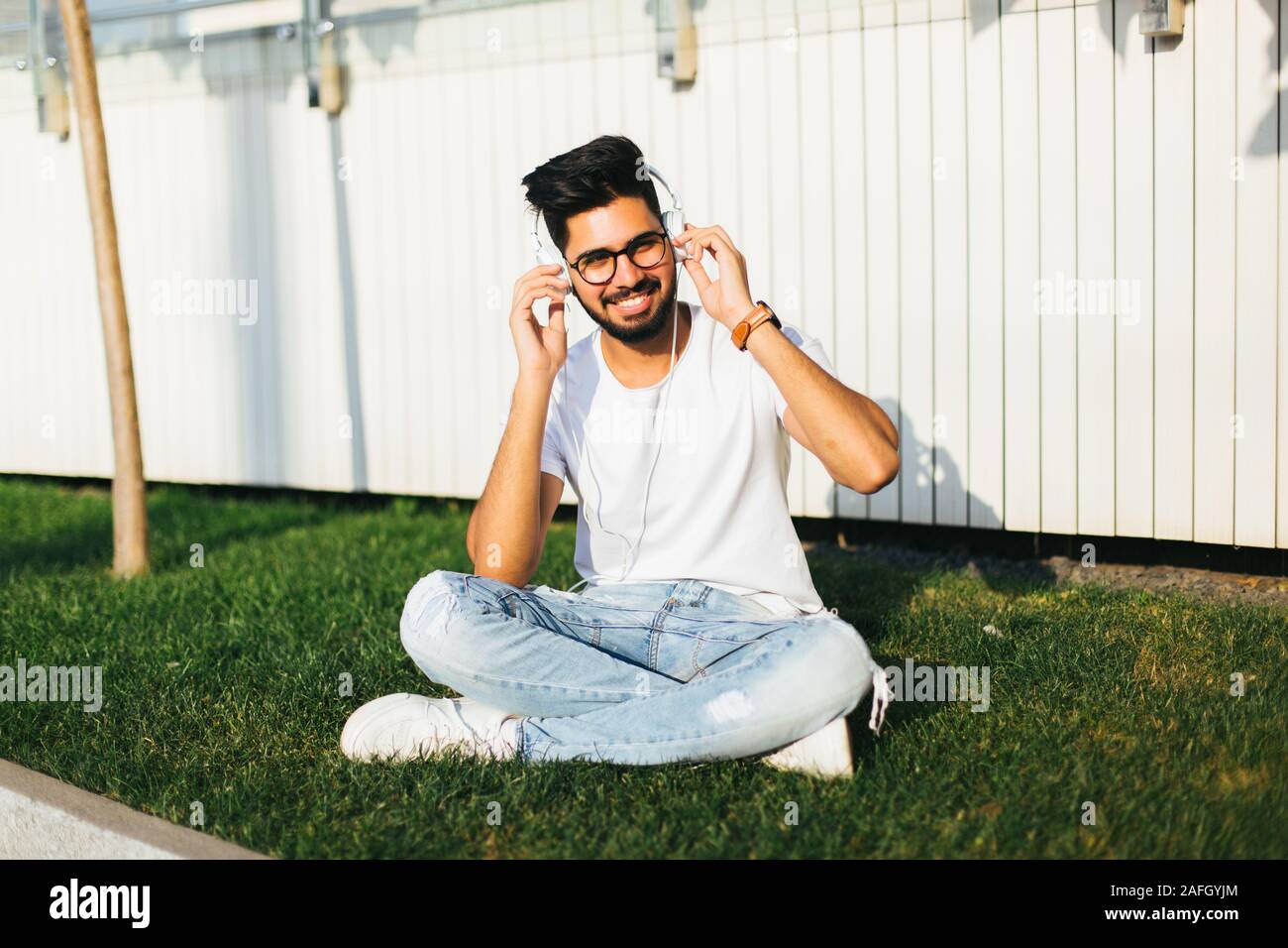 Young indian Student sitting on the grass Stock Photo - Alamy