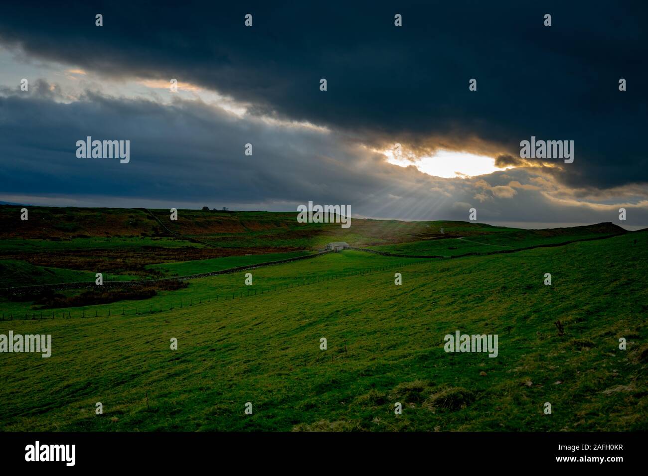 Landscape of a valley covered in lawn surrounded by fences under a ...