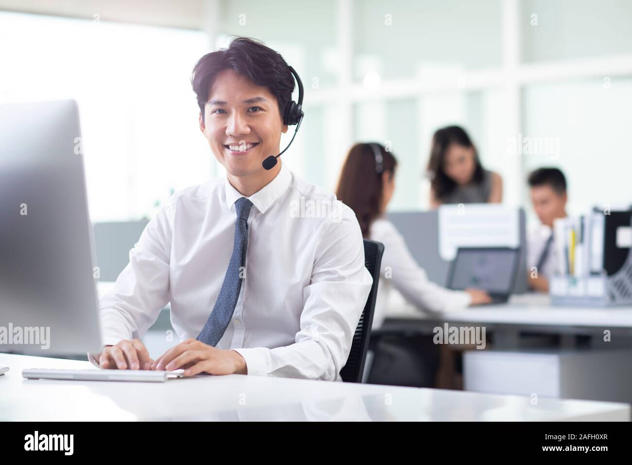 Call center agents working in office Stock Photo - Alamy