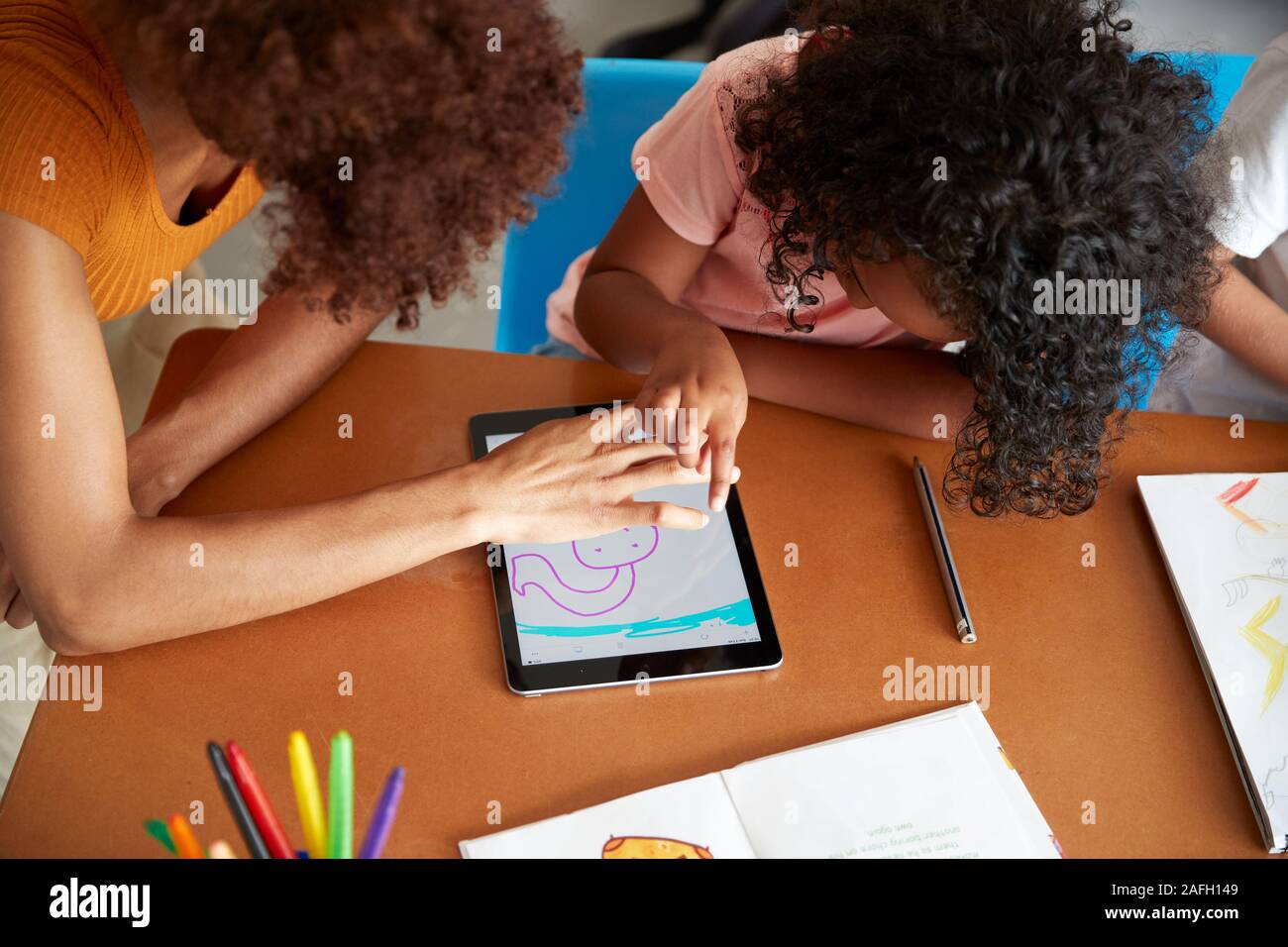Elementary School Teacher And Female Pupil Drawing Using Digital Tablet ...