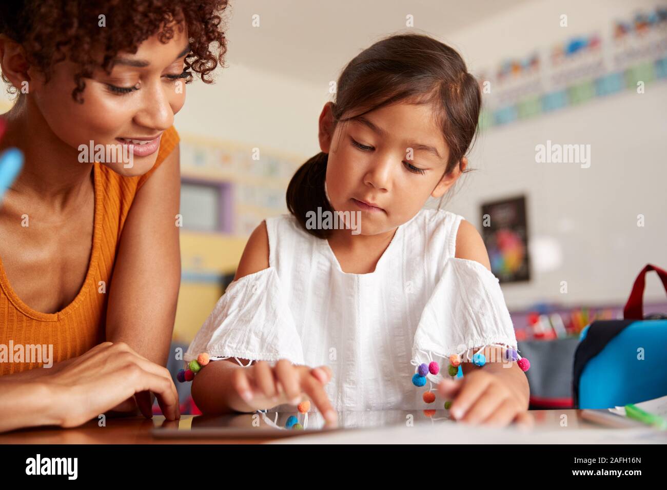 Elementary School Teacher And Female Pupil Drawing Using Digital Tablet ...