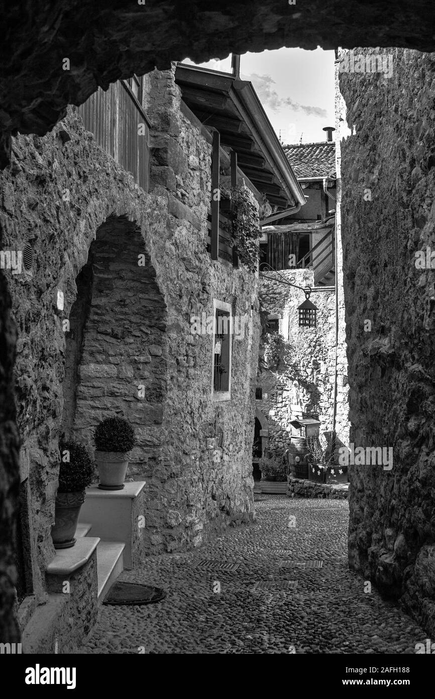 A narrow lane through tunnel arch, Canale di Tenno, Trentino-Alto Adige ...