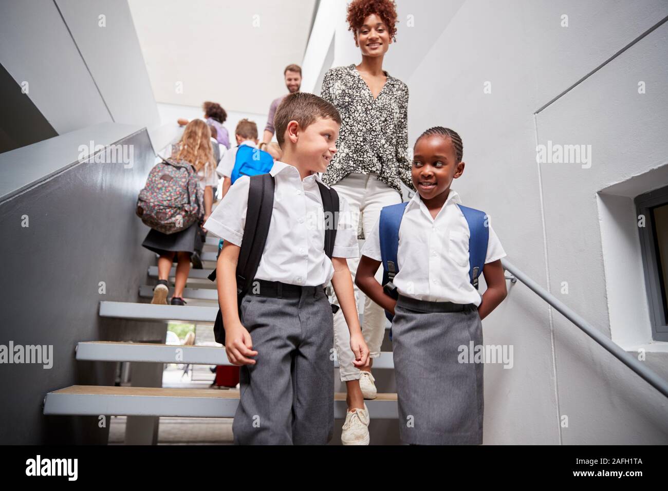 Teacher And Pupils Walking Down Stairs In Busy Elementary School ...
