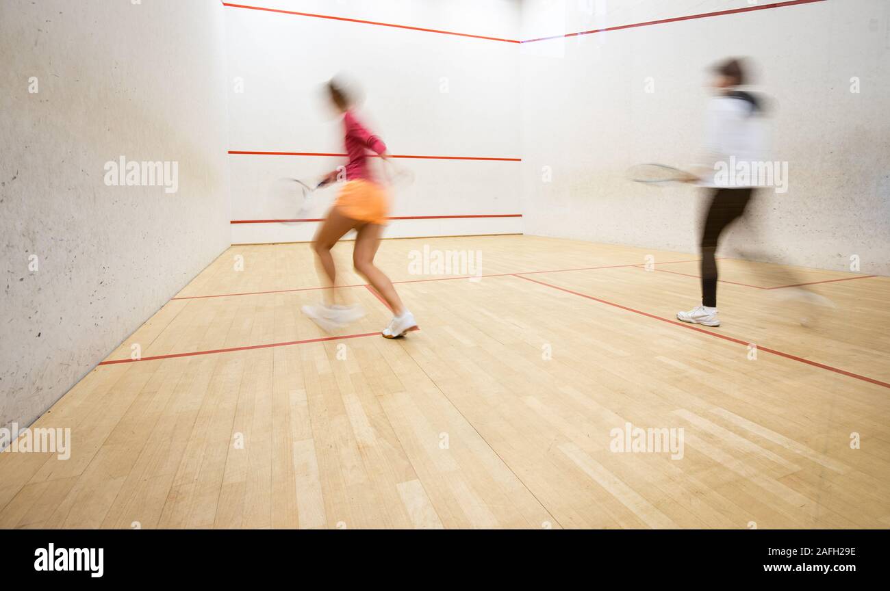 Two Female Squash Players In Action On A Squash Court Motion Blurred Image Color Toned Image