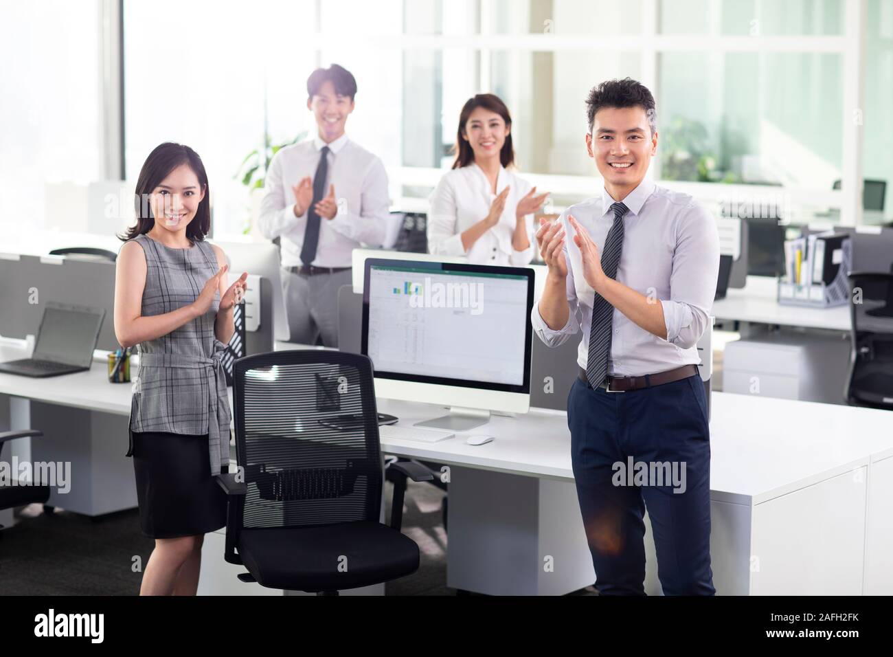 Successful business people clapping in office Stock Photo - Alamy