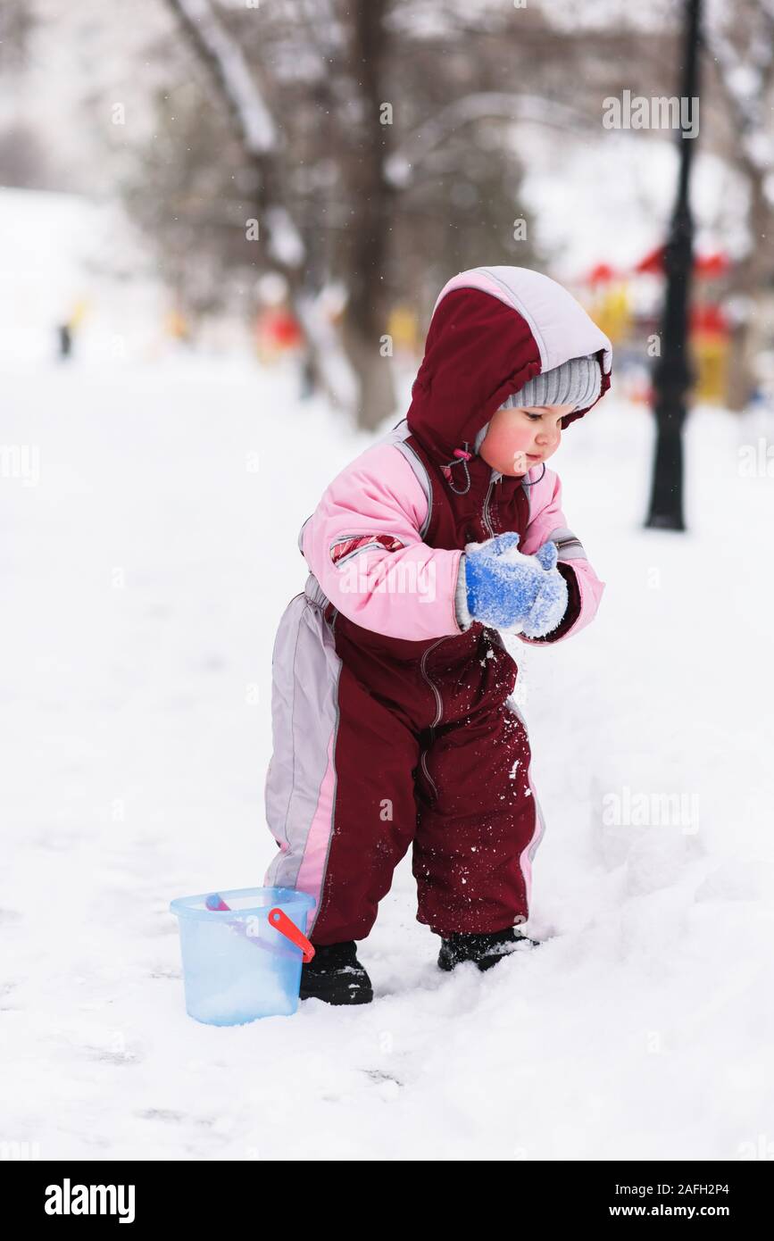 a child puts a bucket in the snow in a bucket Stock Photo - Alamy