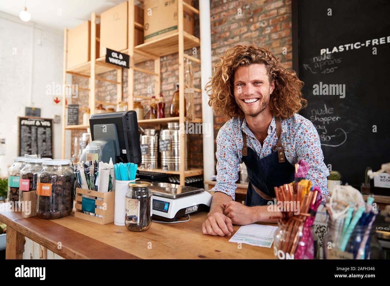 Portrait Of Male Owner Of Sustainable Plastic Free Grocery Store Behind ...