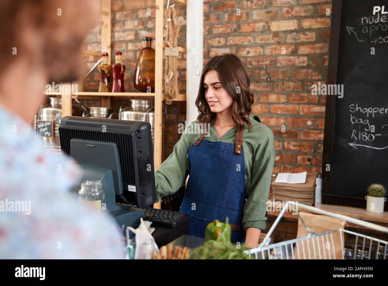 Customer Paying For Shopping At Checkout Of Sustainable Plastic Free ...