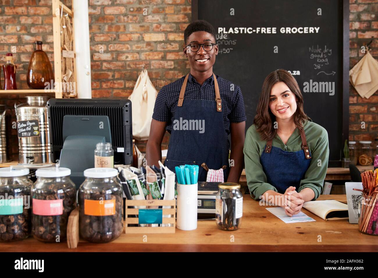 Portrait Of Male And Female Owners Of Sustainable Plastic Free Grocery ...