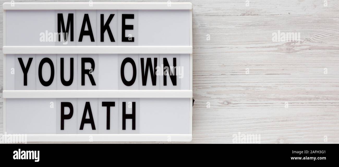'Make your own path' words on a modern board on a white wooden ...