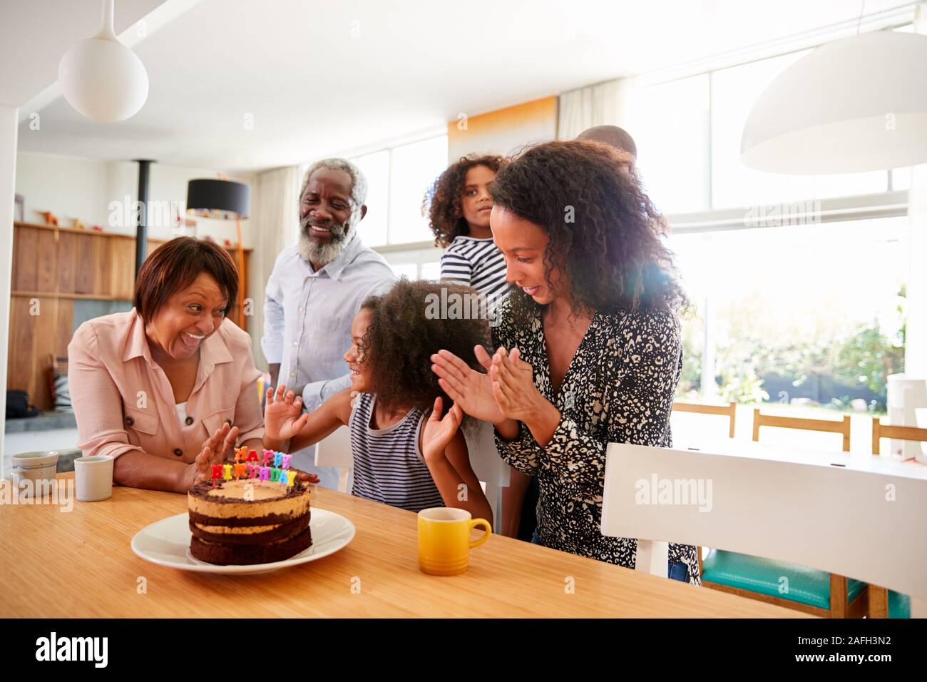 Multi-Generation Family Celebrating Granddaughters Birthday At Home ...