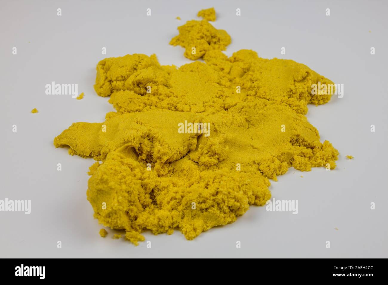 yellow kinetic sand scattered on a white table Stock Photo - Alamy