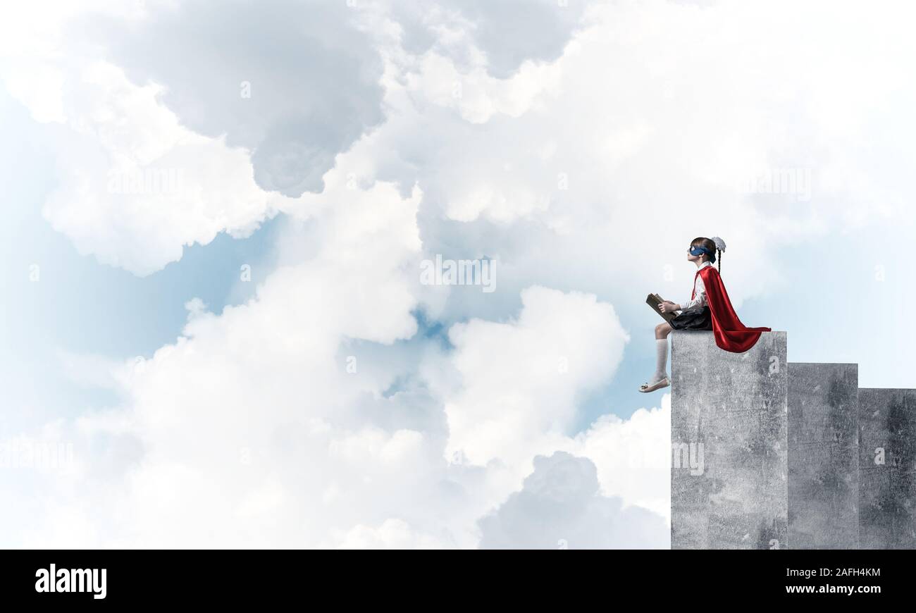 Girl power concept with cute kid guardian against cloudscape background ...