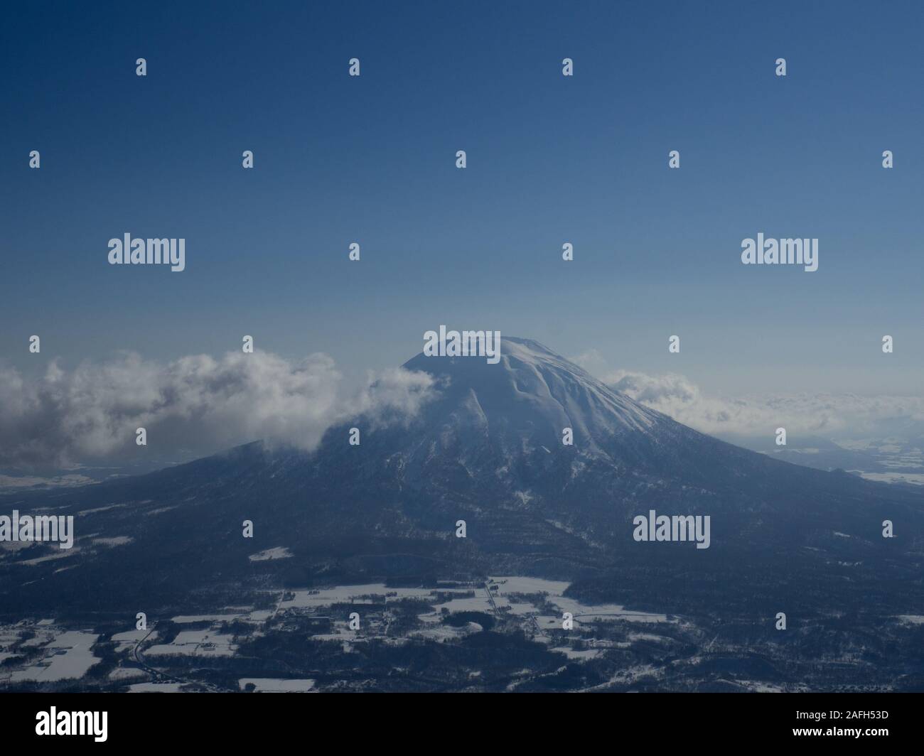 Beautiful scenery of a mountain blending in with the fluffy clouds ...