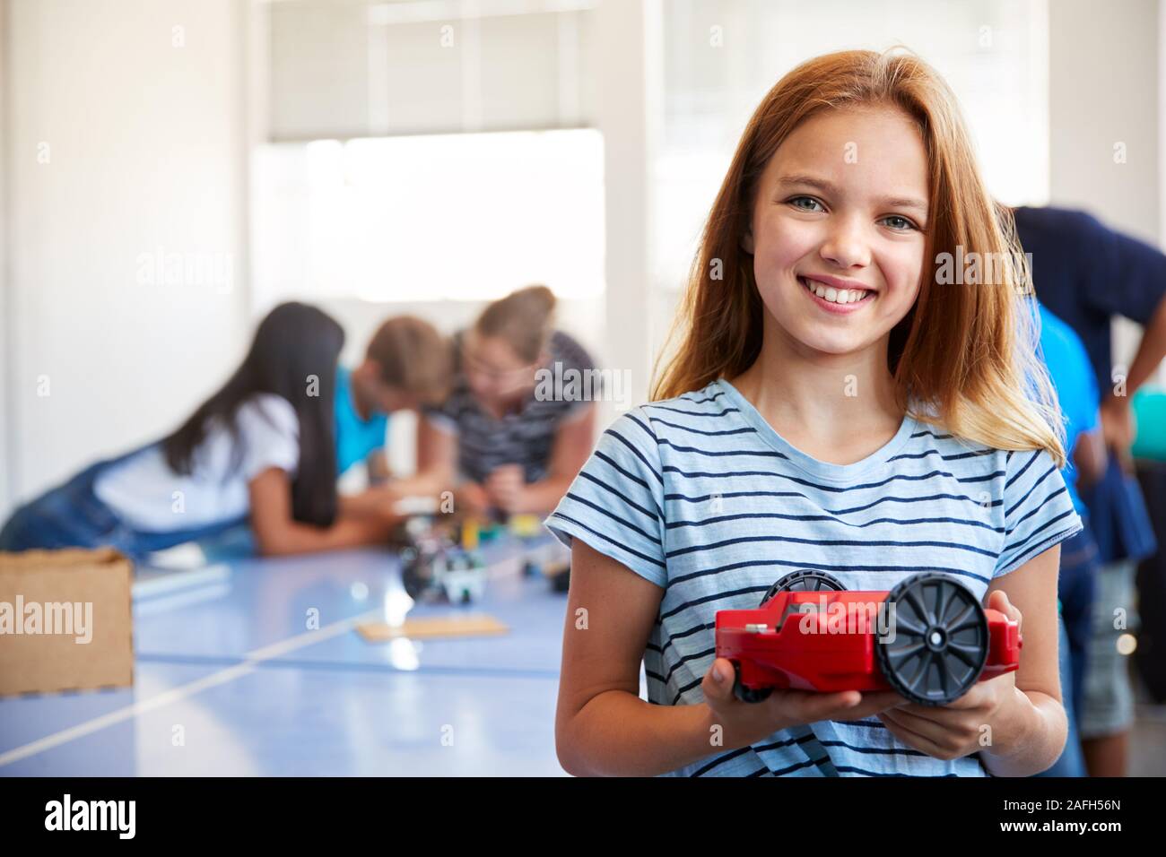 Portrait Of Female Student Building Robot Vehicle In After School ...