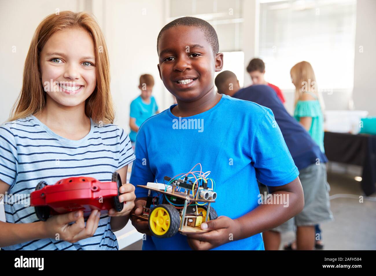 Portrait Of Male And Female Students Building Robot Vehicle In After ...