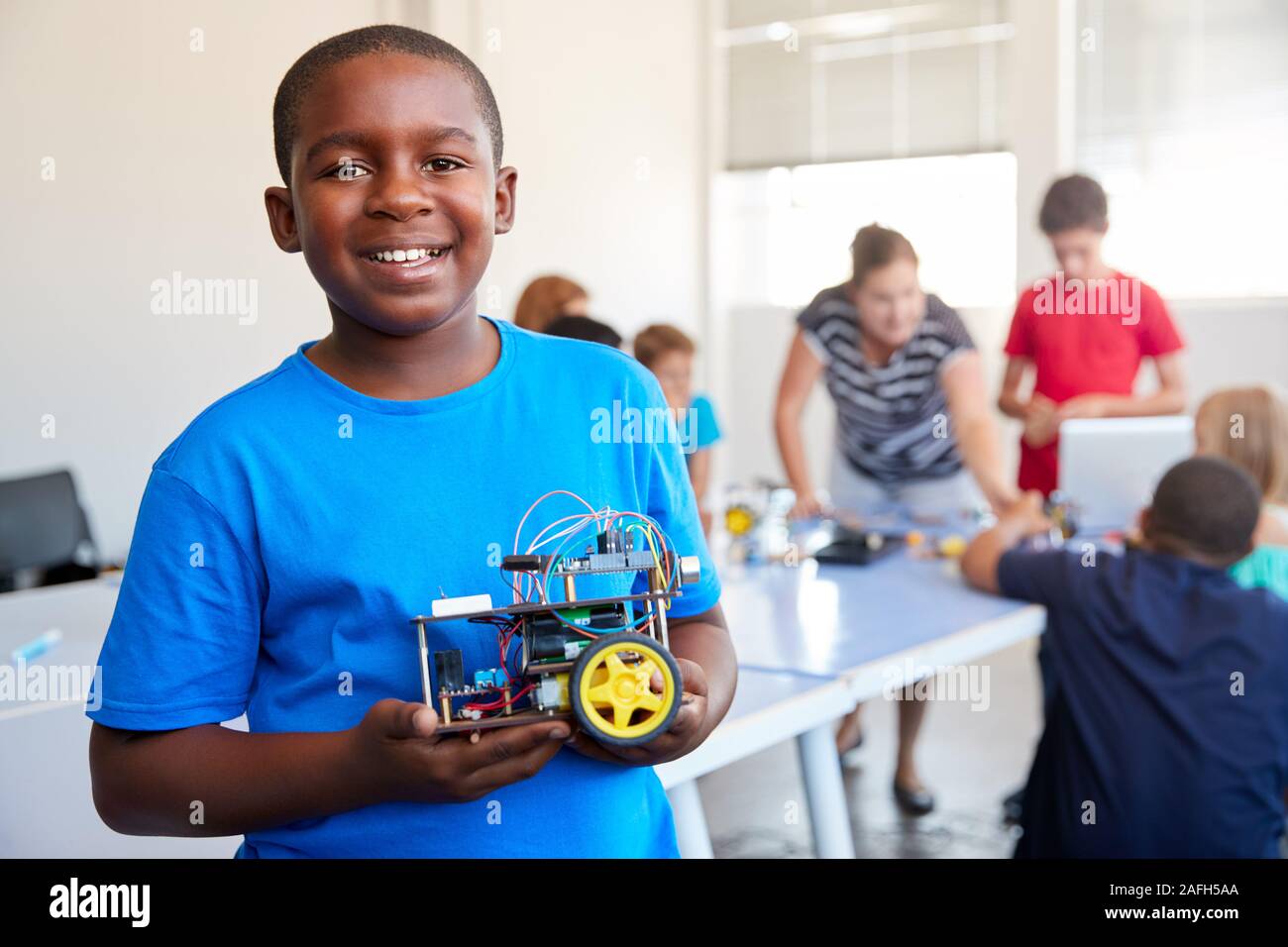 Portrait Of Male Student Building Robot Vehicle In After School ...