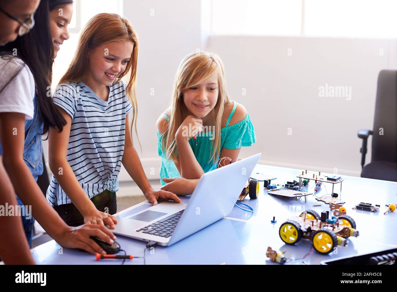 Three Female Students With Teacher Building Robot Vehicle In After ...