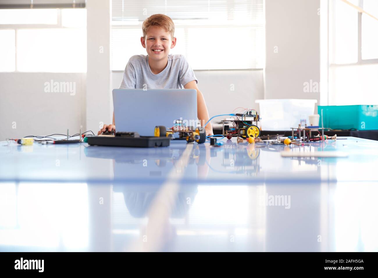 Portrait Of Male Student Building And Programing Robot Vehicle In ...