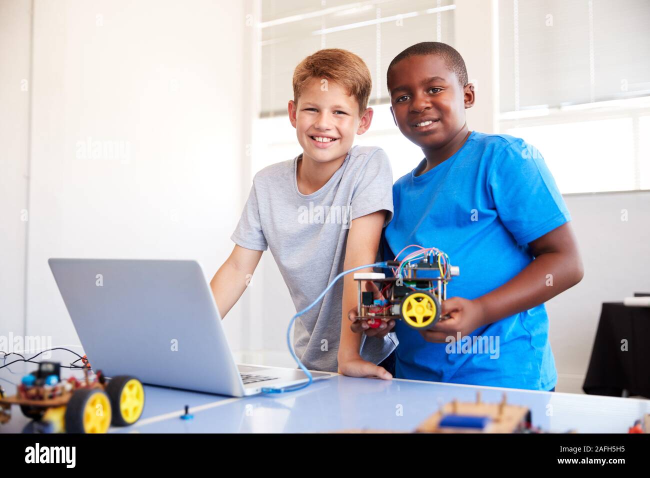 Portrait Of Two Male Students Building And Programing Robot Vehicle In School Computer Coding ...