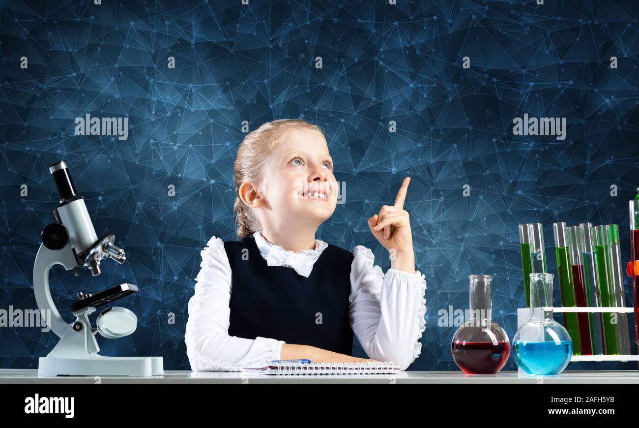 Little girl scientist sitting at desk Stock Photo - Alamy
