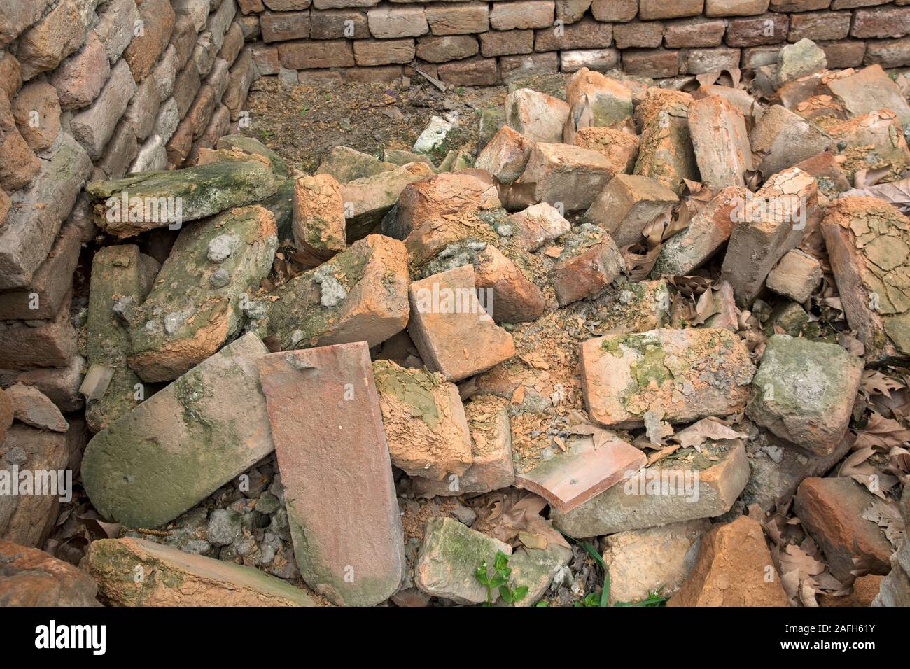 A pile of bricks from a collapsed wall and a few tiles Stock Photo - Alamy