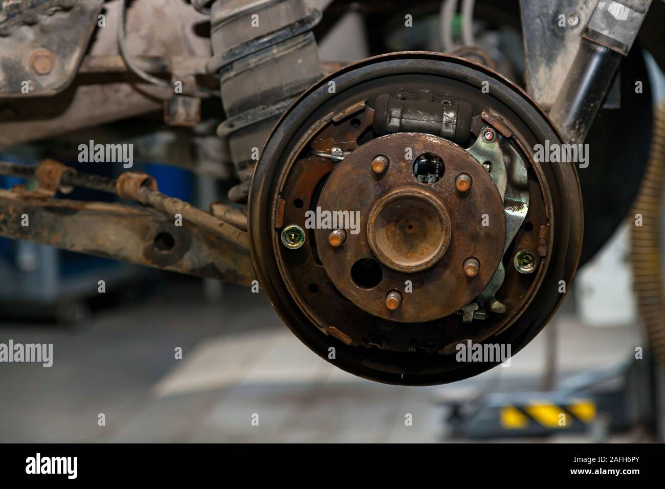 A close-up on the rear brake system of a car with hub on a lift in a ...