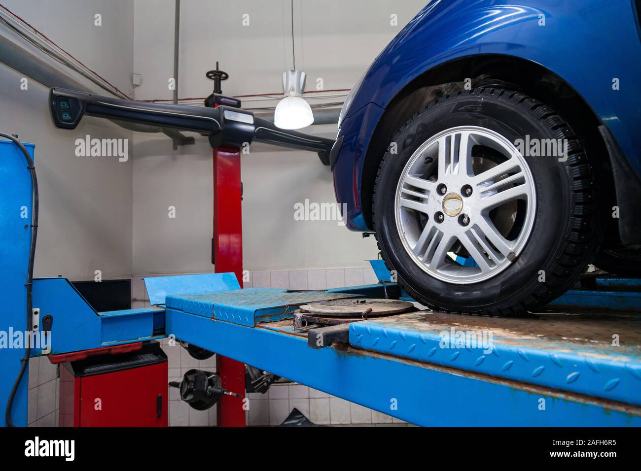 Blue car front wheel view stands on the stand wheel alignment ...