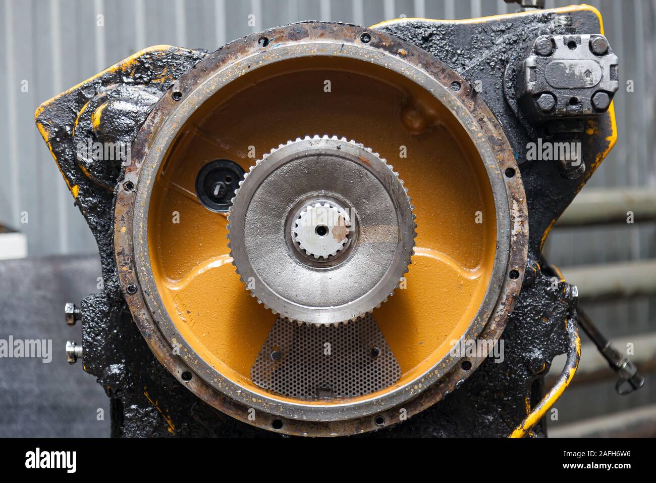 A side view of a yellow gearbox taken from a car or tractor in a ...