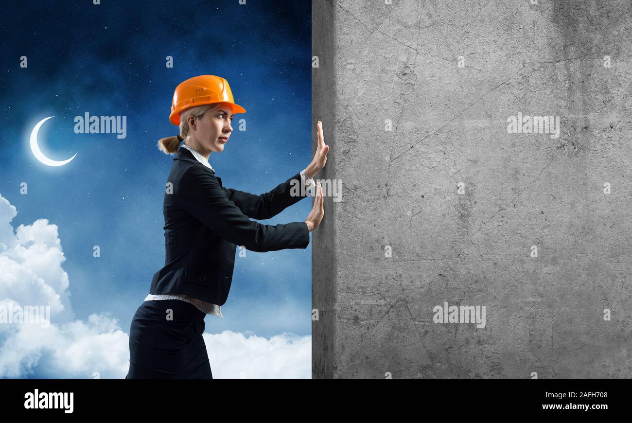 Beautiful woman architect pushing concrete wall Stock Photo - Alamy