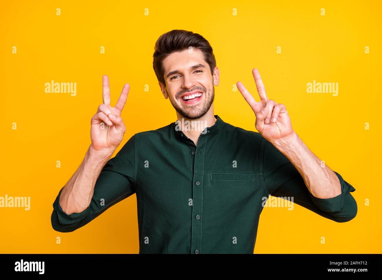 Photo of cheerful positive man showing you double v-sign greeting you ...