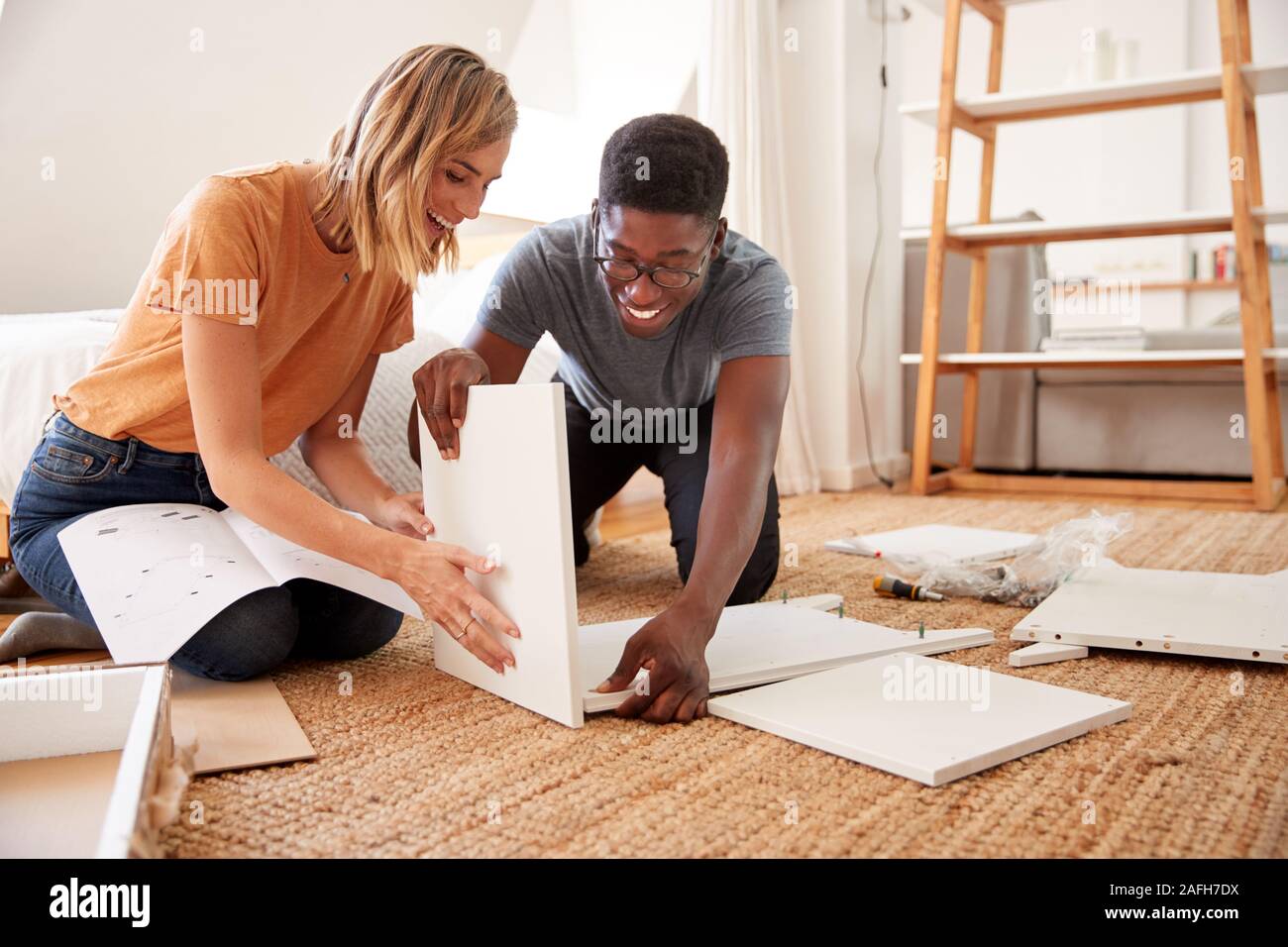 Couple In New Home Putting Together Self Assembly Furniture Stock Photo ...