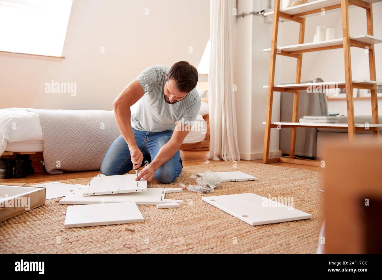 Man In New Home Putting Together Self Assembly Furniture Stock Photo ...