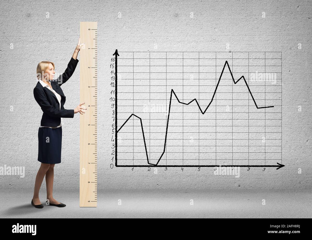 Woman in business suit holding big ruler Stock Photo - Alamy