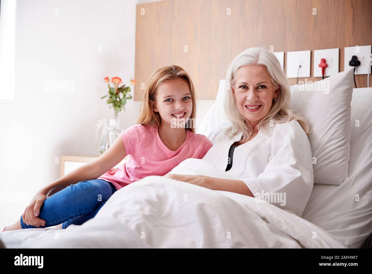 Portrait Of Granddaughter Visiting Grandmother In Hospital Bed Stock ...