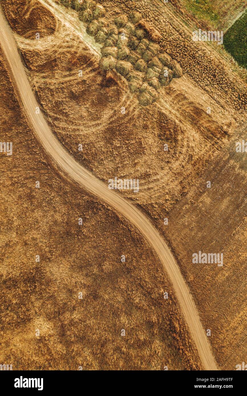 Aerial view of dusty dirt road through grassy plain landscape, top view ...
