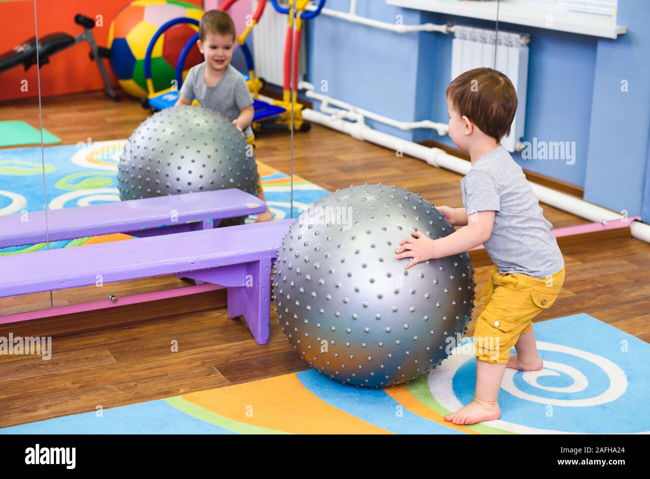little child playing with a fitball in the gym Stock Photo - Alamy