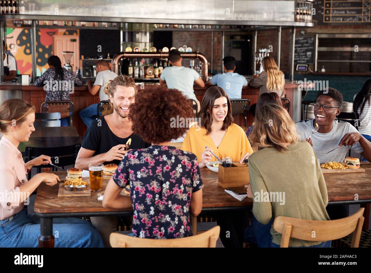 Group Of Young Friends Meeting For Drinks And Food In Restaurant Stock ...