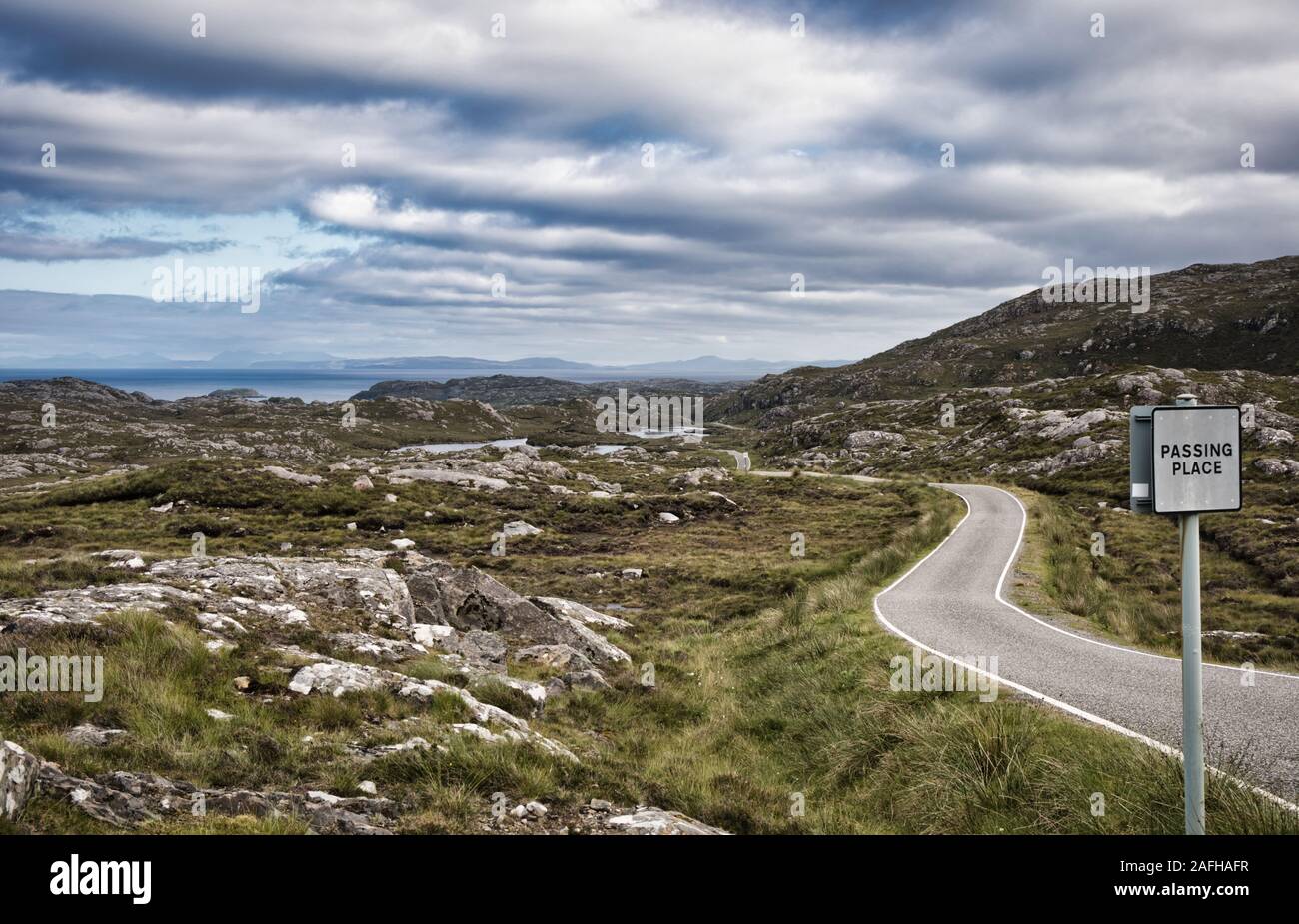 Passing place sign on remote single track road amongst barren scenery ...