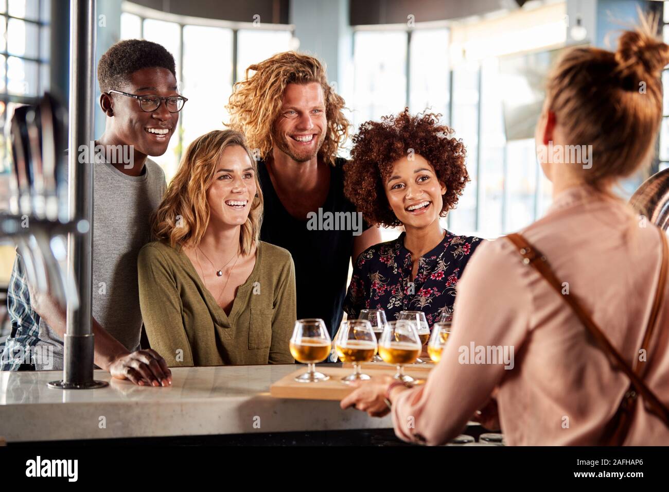 Waitress Serving Group Of Friends Beer Tasting In Bar Stock Photo - Alamy
