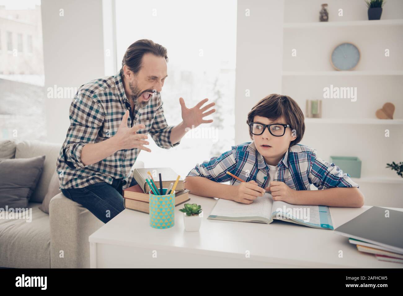 Photo of aggressive dad screaming at his small son who does not ...