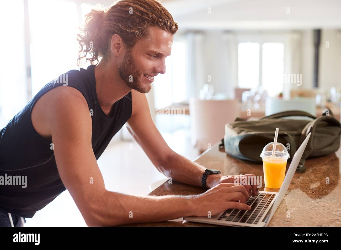 Millennial white man checking fitness app on laptop at home after a ...