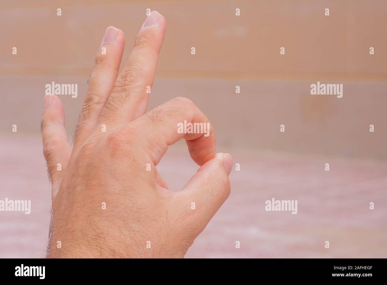 Conceptual okay hand sign on soft orange background. Agreement, yes ...