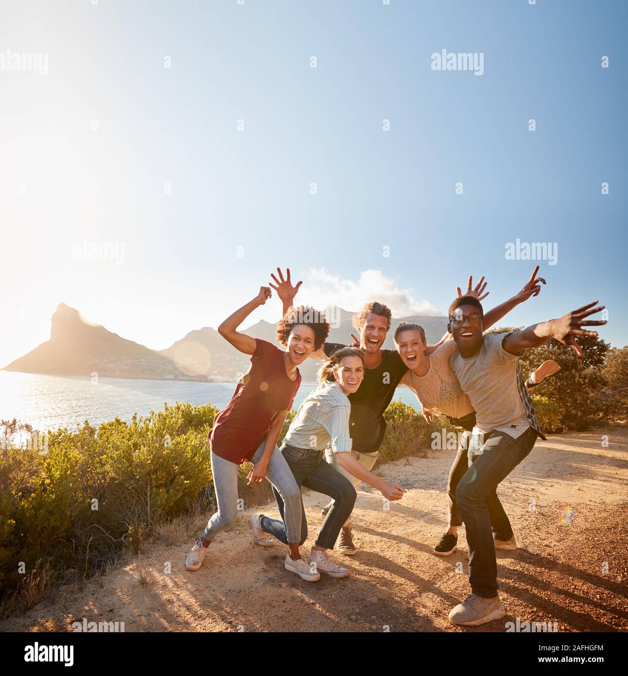 Five millennial friends on a road trip have fun posing for photos on a ...