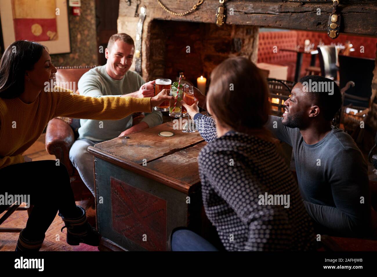 Group Of Friends Making Toast As They Meet For Lunchtime Drinks In ...